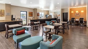 Um lobby moderno de hotel com área de bar, assentos e vista para o exterior.