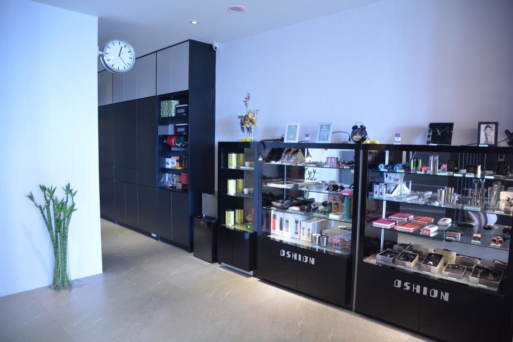 Um espaço comercial moderno com prateleiras pretas identificadas com 'OSHION'.