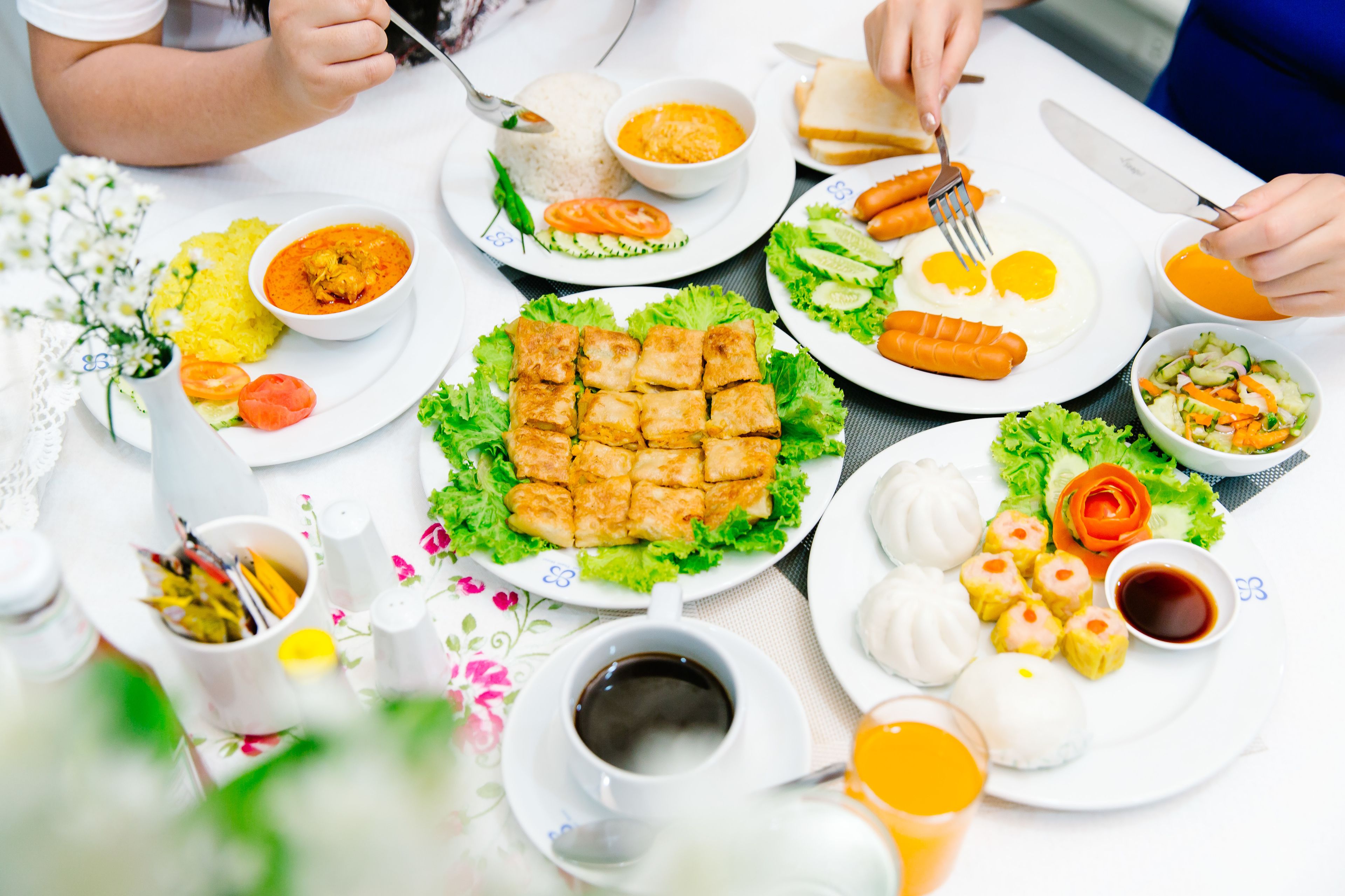 Uma mesa com diversos pratos, incluindo arroz, sopa e legumes.