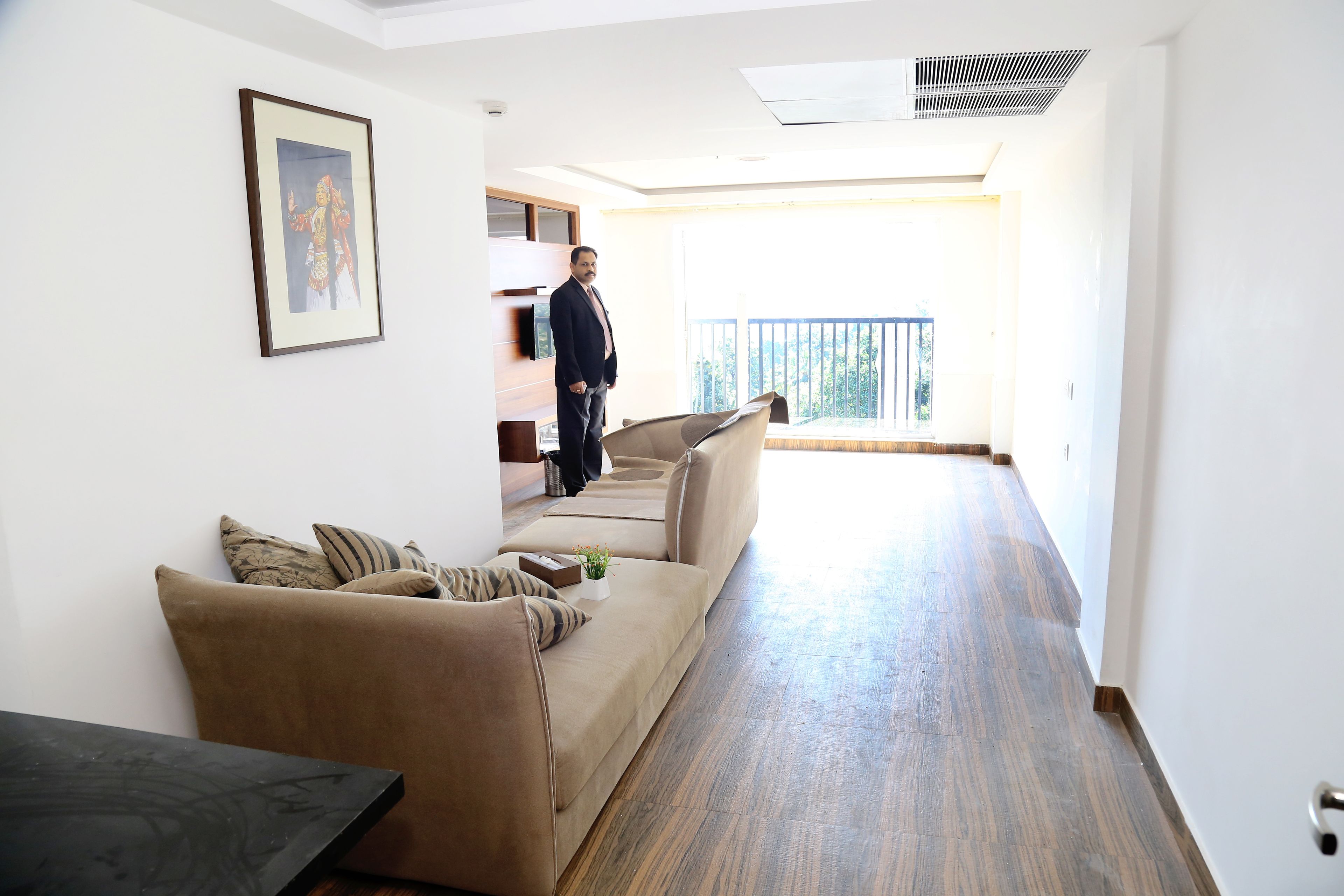 Uma sala de estar moderna com um sofá, uma mesa de centro e um quadro na parede.
