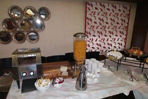 Disposição de buffet de café da manhã com máquina de café, dispensador de cereais e diversas opções para o café.