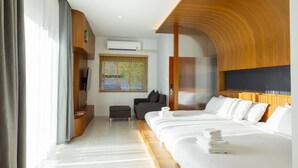 Quarto de hotel moderno com uma cama grande, um sofá, uma televisão e uma janela com persianas.