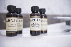 Quatro embalagens de gel de banho e shampoo Argane sobre uma superfície branca.
