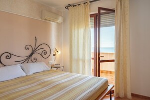 Suíte superior, 1 cama Queen e sofá-cama, sacada, vista para o mar | Cofres nos quartos, escrivaninha, espaço de trabalho para notebook