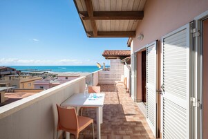 Suite Deluxe, 1 cama queen-size e sofá-cama, varanda, vista parcial para o mar | Terraço/pátio interior