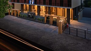 Um hotel moderno com vários andares, janelas amplas e um logotipo marcante na fachada.