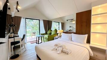 Quarto de hotel moderno com uma cama grande, uma escrivaninha, uma cadeira e um sofá.