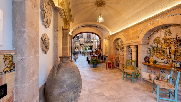 Interior espaçoso com teto alto, paredes de pedra e um arco central que dá acesso a uma área de jantar.