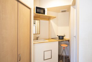 Um frigorífico, um micro-ondas, uma placa de cozinha 