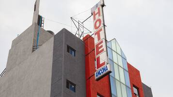 Placa de hotel com os dizeres 'HOTEL' e 'ANCONA' numa fachada.