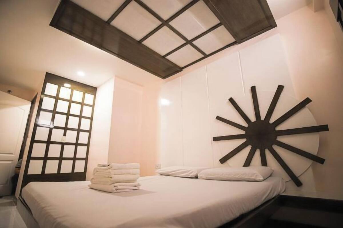 Quarto de hotel com cama, uma grande decoração de parede e janela com vista.