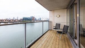 Varanda com vista para o horizonte urbano e um corpo d'água.
