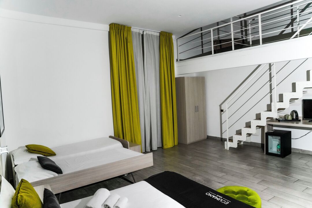 Um apartamento moderno com quarto no estilo loft, área de jantar e cozinha.