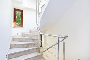 Uma escadaria com guarda-corpo de metal e janela de madeira.