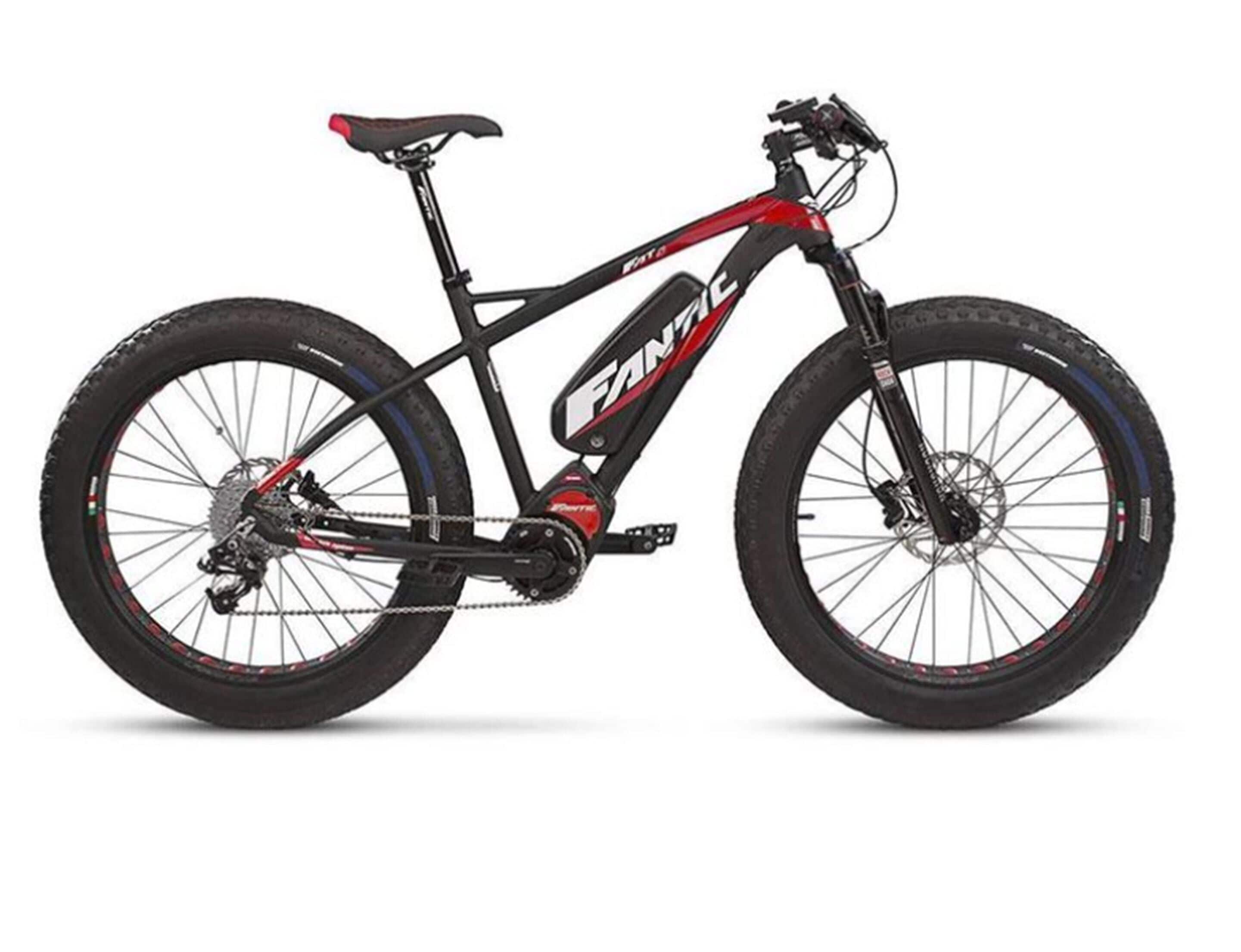 Uma bicicleta de montanha com quadro preto, detalhes em vermelho e garfo dianteiro com suspensão.