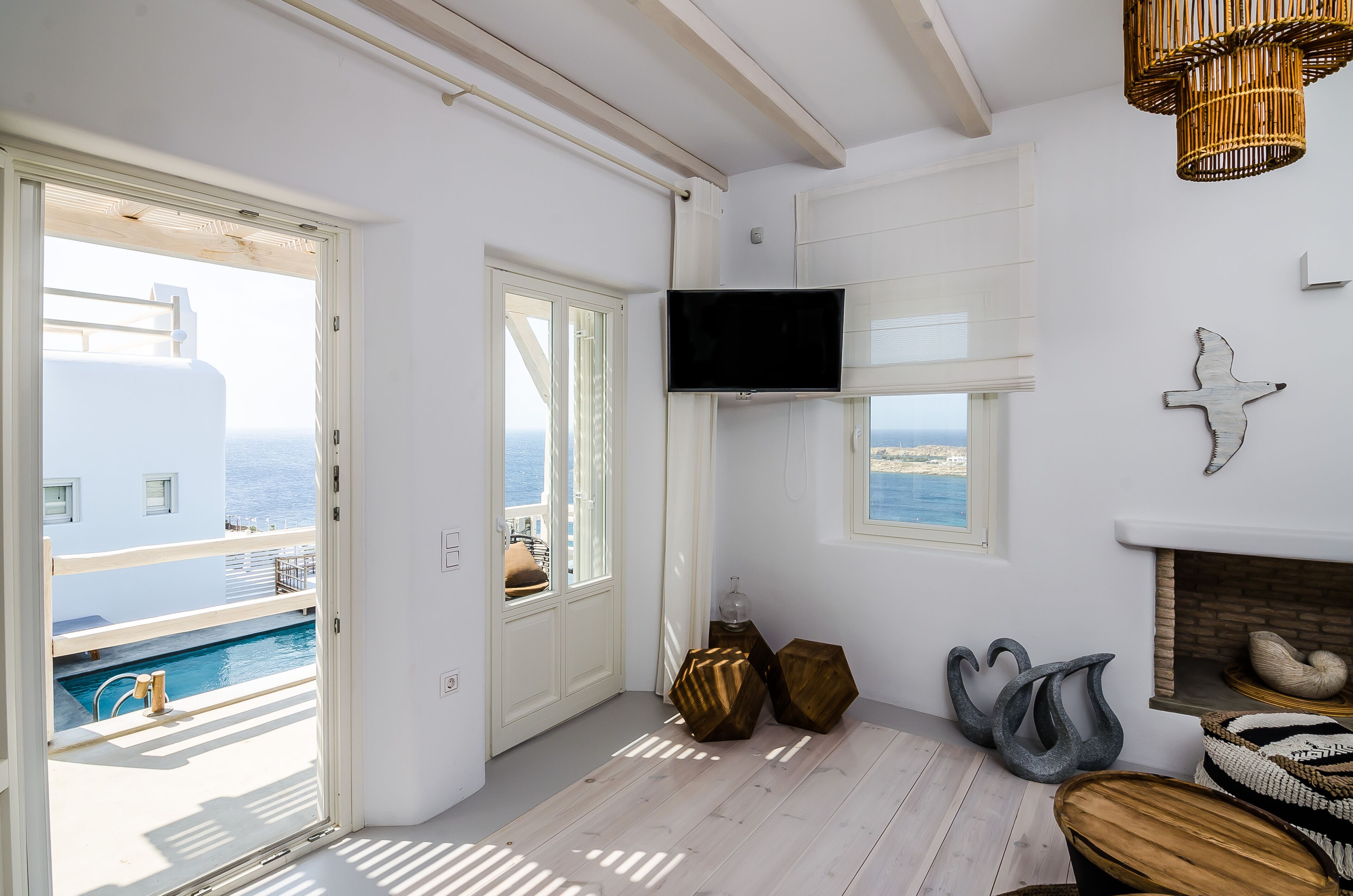 Quarto com uma janela grande, televisão de tela plana e lareira.