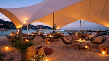 Uma praia privada, espreguiçadeiras, guarda-sóis de praia