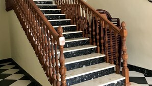 Uma escadaria com balaústres de madeira e piso xadrez.