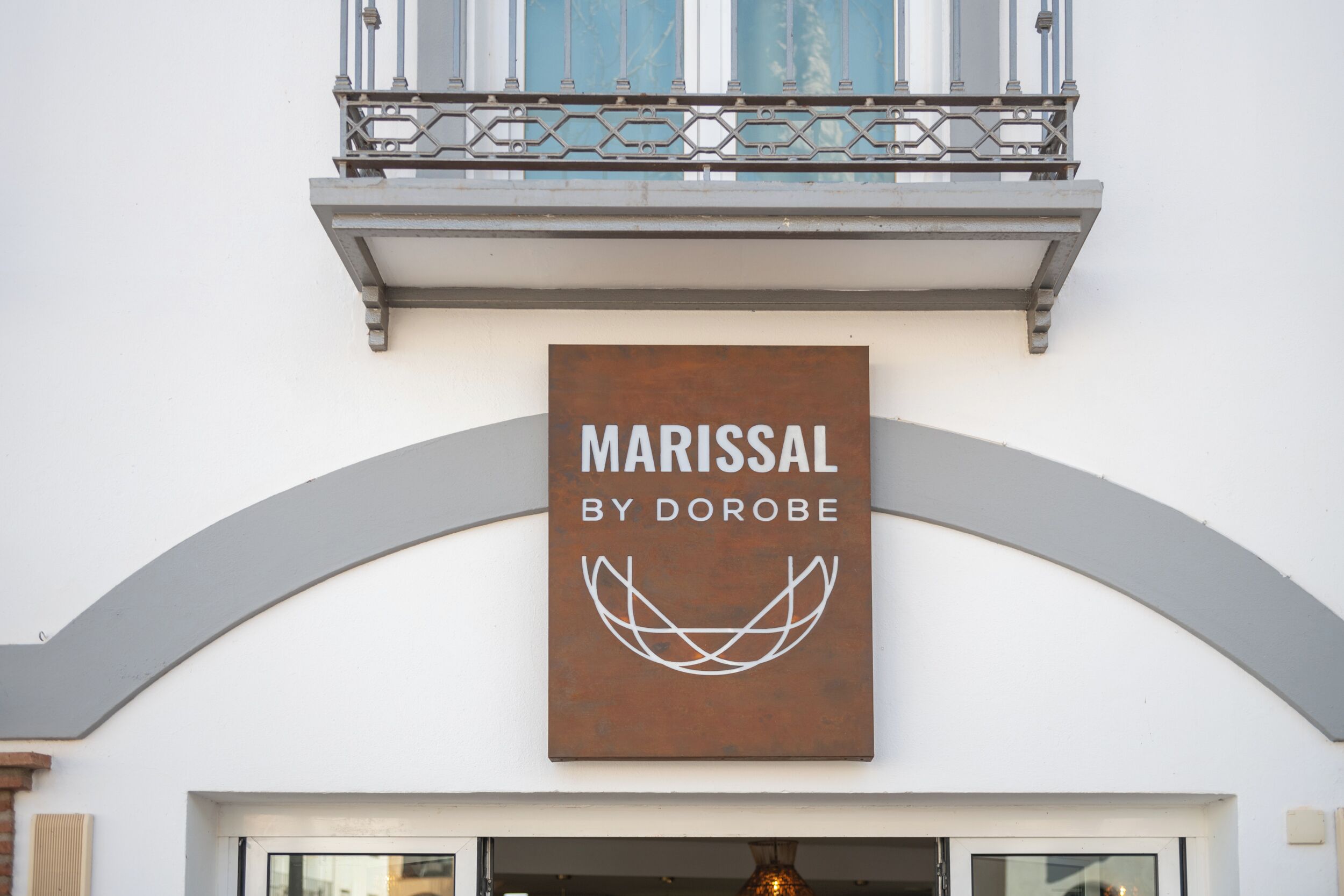Uma placa com o texto 'MARISSAL BY DOROBE' acima de uma porta.