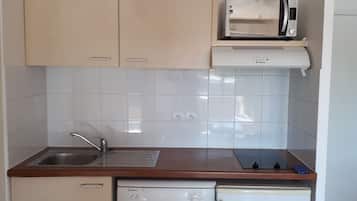 Um frigorífico, um micro-ondas, utensílios de cozinha