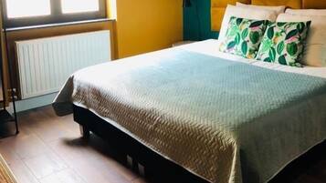 Um quarto com uma cama, uma janela com persianas, um radiador e um globo fixado na parede.