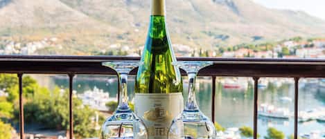 Uma garrafa de vinho Suho sobre uma mesa, com vista para um lago e montanhas.