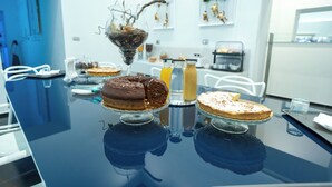 Uma mesa de jantar moderna com três bolos e um vaso de vidro decorativo.