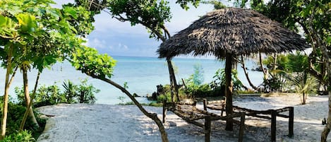 Perto da praia, praia de areia branca, espreguiçadeiras, caiaque