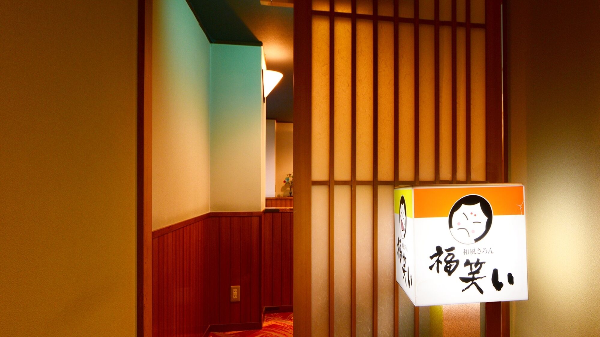 Um corredor com portas deslizantes tradicionais japonesas e uma placa com caracteres japoneses.