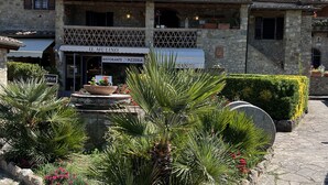 Um edifício de pedra com um restaurante chamado "Il Mulino" e uma pizzaria.