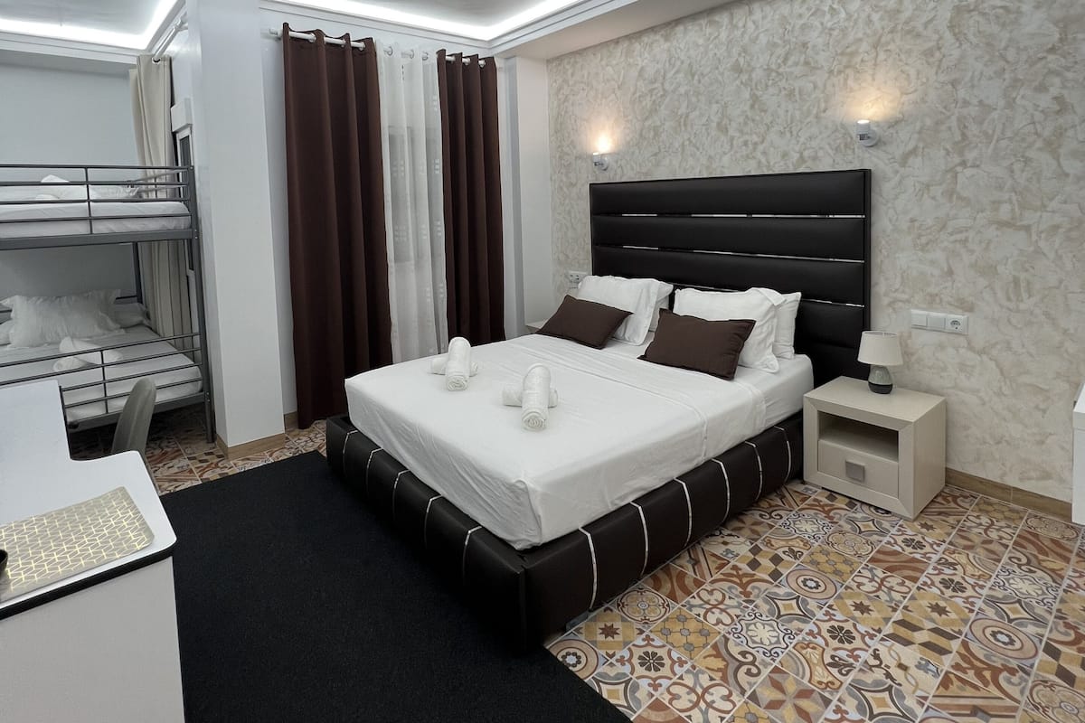Quarto de hotel moderno com uma cama grande, uma escrivaninha e uma cadeira.