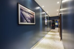 Um corredor com fotografias emolduradas nas paredes, piso de mármore e design moderno.
