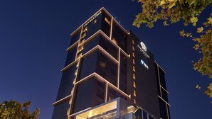 Um edifício moderno com uma placa grande de 'DOUBLETREE', apresentando uma fachada geométrica e janelas iluminadas.