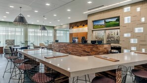Um lobby de hotel moderno com um balcão de recepção espaçoso, área de estar e um bar.