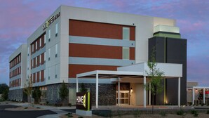 Um hotel moderno com uma placa indicando "HOME 2 Suites by Hilton" e uma entrada coberta.