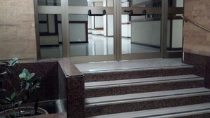 Escada com corrimão que leva a um quarto com porta de vidro deslizante.
