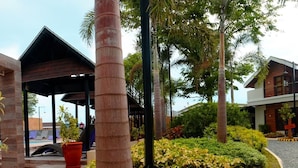 Um hotel moderno com área de piscina, passarelas cobertas e paisagismo exuberante.