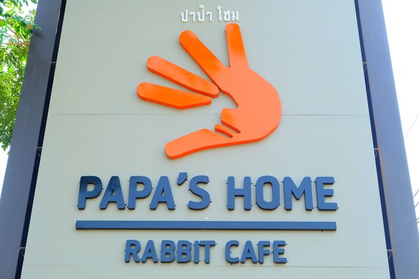 Placa para o Café Papa's Home Rabbit com um grande símbolo de mão laranja.