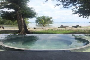 Uma banheira de hidromassagem circular com vista para um lago e montanhas ao longe.