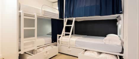 Quarto com beliches, dois em total, cada um com escada e uma gaveta.