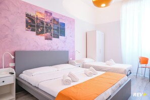 Quarto de hotel com duas camas, uma parede de mármore com obra de arte, um guarda-roupa e uma cadeira.