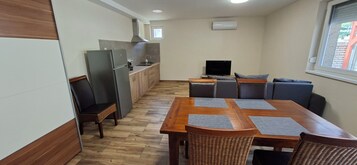 Apartamento superior, 1 quarto | Sala de estar | TV de tela plana 100 cm com canais a cabo, TV