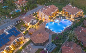 Uma piscina grande cercada por vários edifícios com áreas de estar ao ar livre e um pátio bem iluminado.