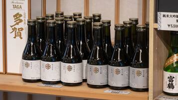 Uma estante com várias garrafas de vinho, cada uma com etiqueta com caracteres japoneses e um preço.