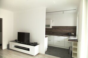 Apartamento Deluxe, 2 quartos | Sala | TV de ecrã plano, leitor de DVD 