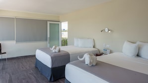 Quarto de hotel com duas camas, uma escrivaninha e uma cadeira.