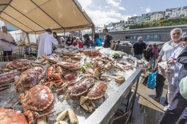 Mercado de frutos do mar com uma variedade de peixes e mariscos expostos em gelo.