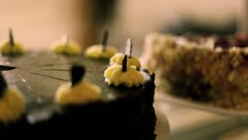 Um close-up de um bolo de chocolate com cobertura amarela e velas.