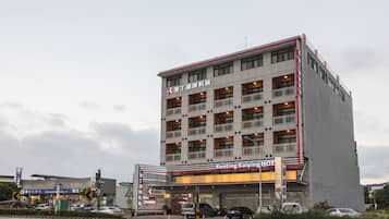 Um hotel de vários andares com design moderno, apresentando uma entrada imponente e sinalização com o nome