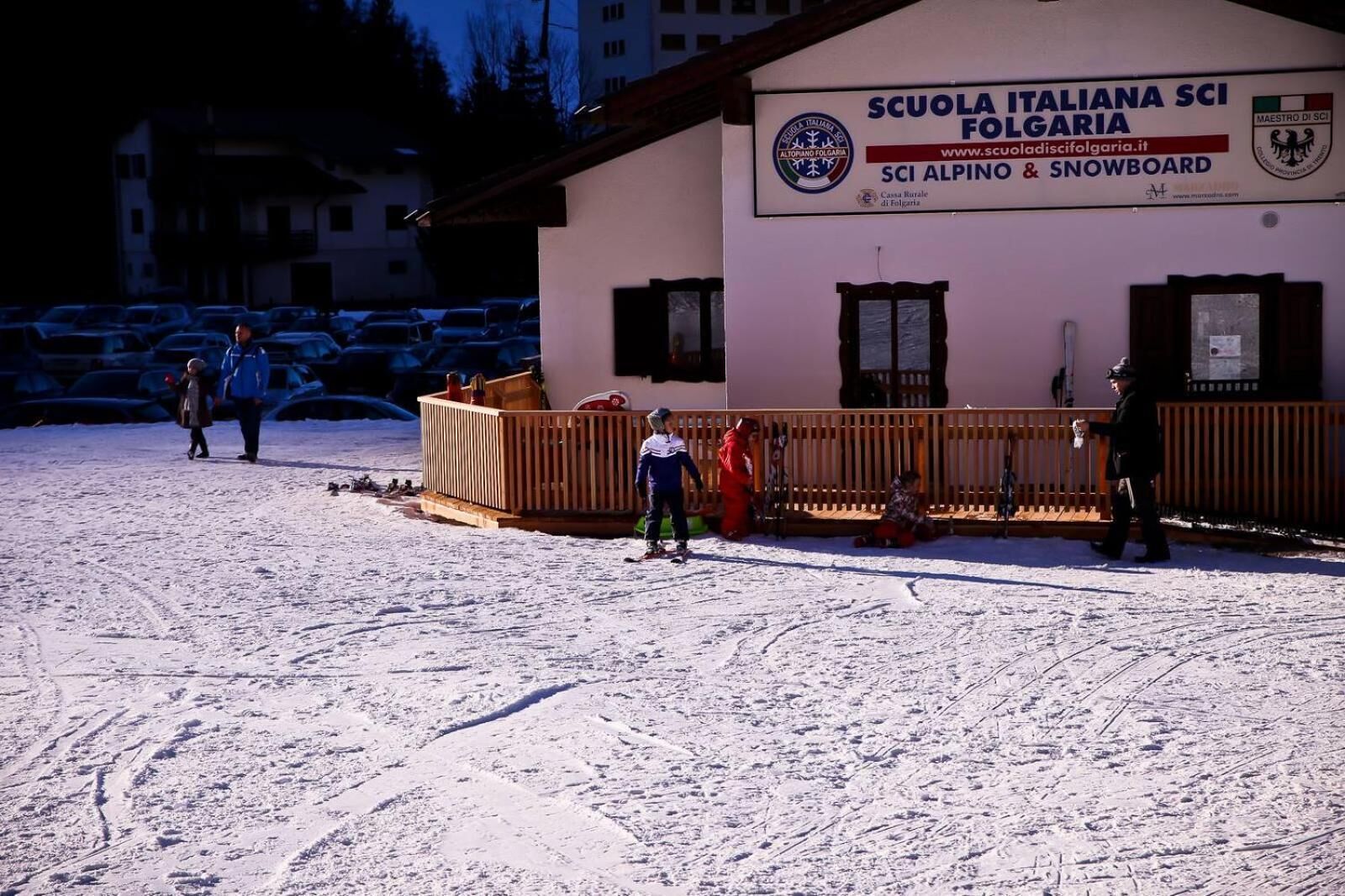 Área externa coberta de neve com um edifício identificado como 